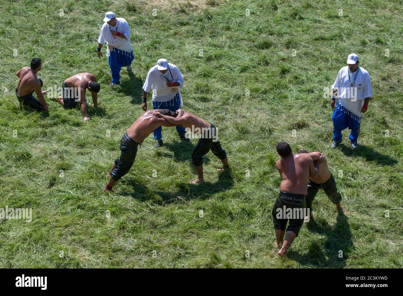 Wrestlers battle for victory under the watchful eyes of referees at the ...