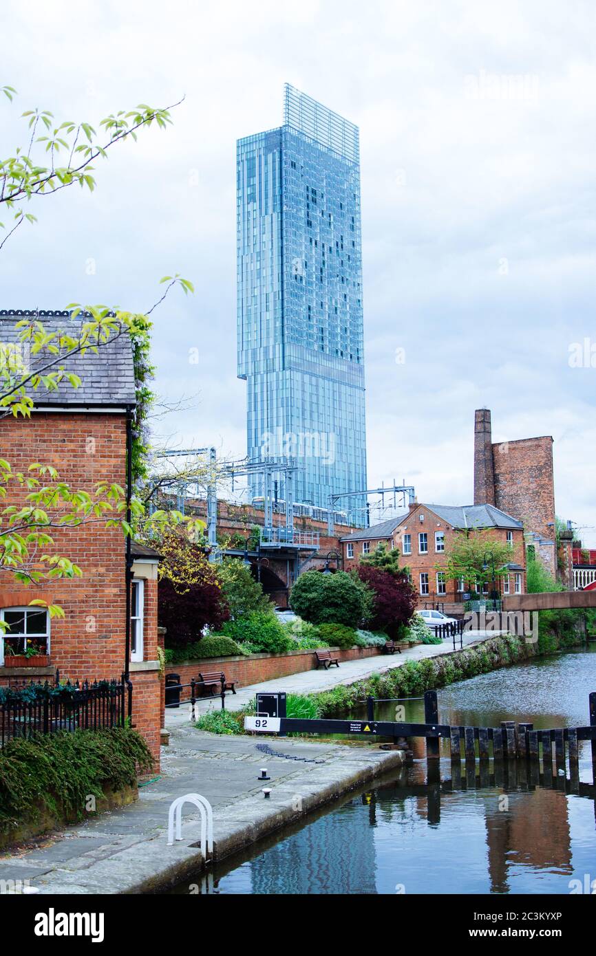 Vertical shot of a glass skyscraper and small brick houses Stock Photo ...