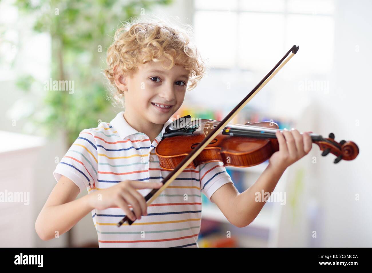 Child playing violin. Remote learning from home. Arts for kids. Little ...