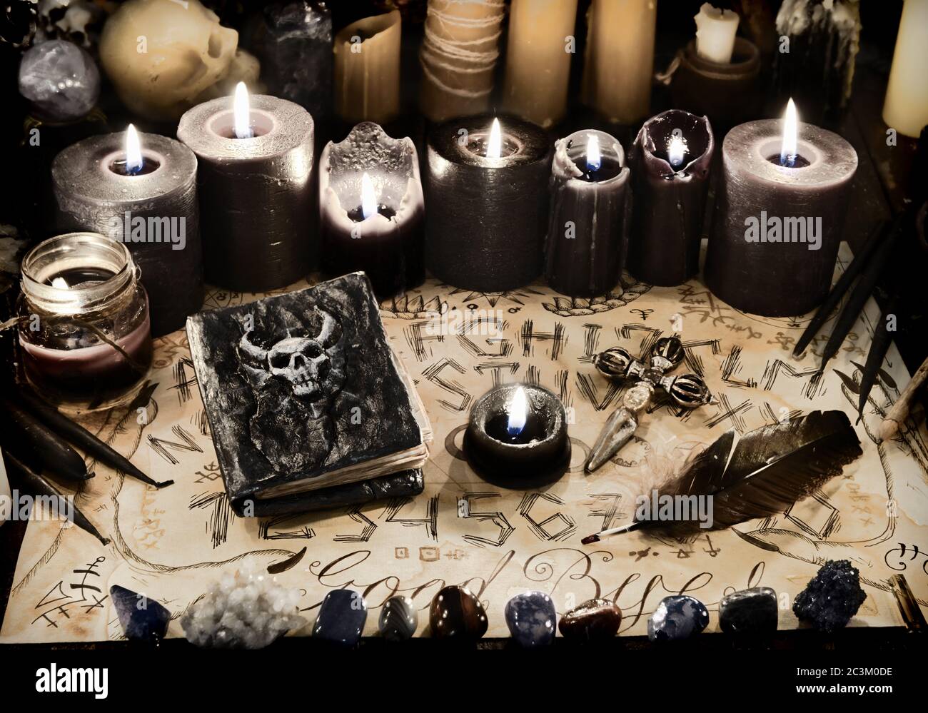 Evil book with black magic spells, candles and ouija board on witch ...