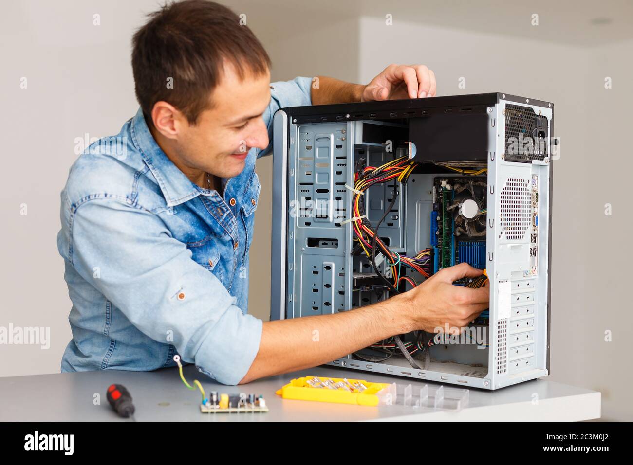 Young technician working on broken computer in his office Stock Photo ...