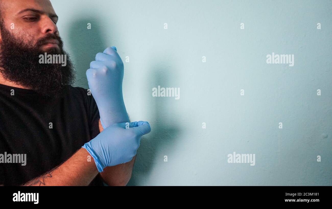 Bearded male wearing disposable gloves Stock Photo - Alamy