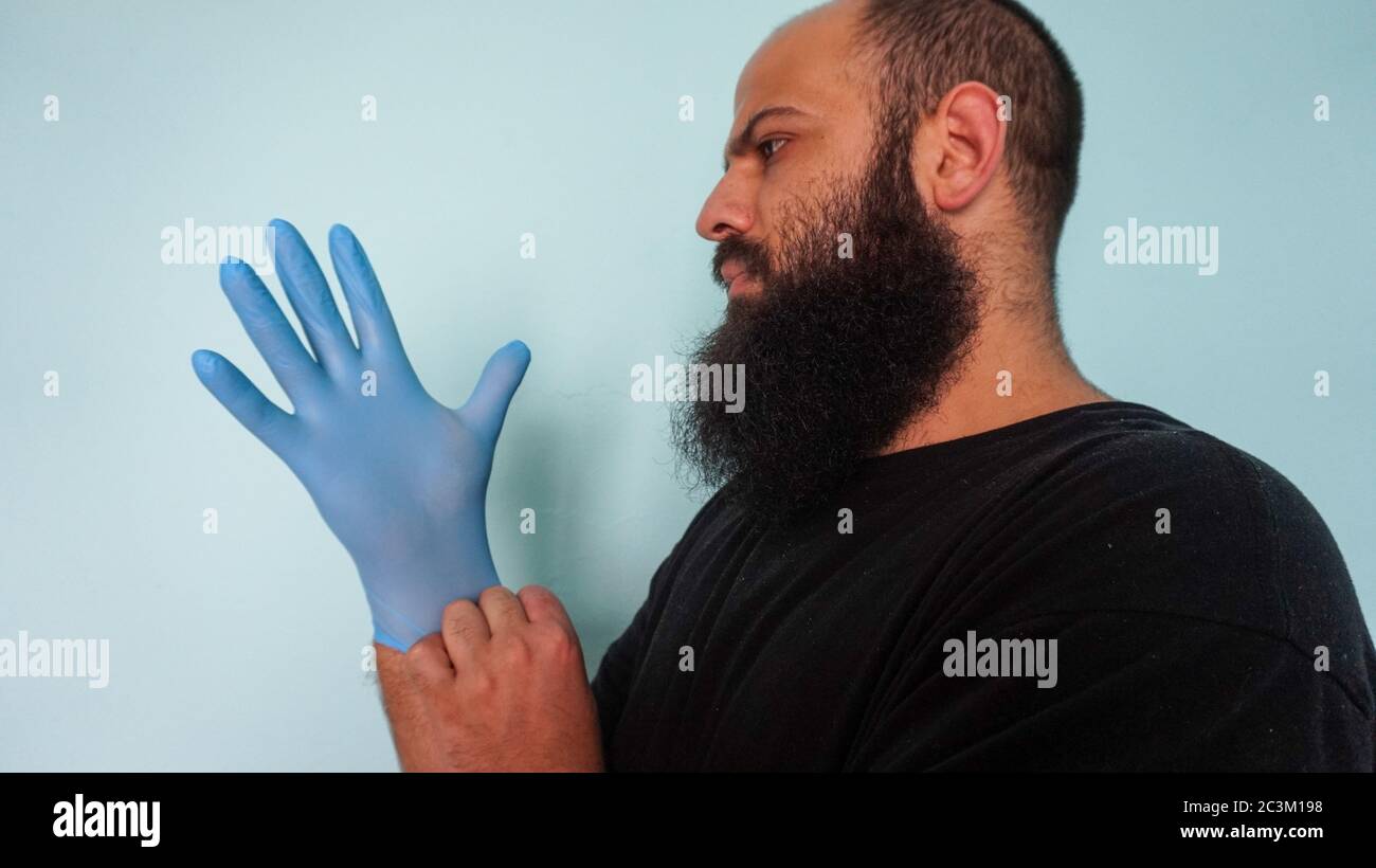 Bearded male wearing disposable gloves Stock Photo - Alamy
