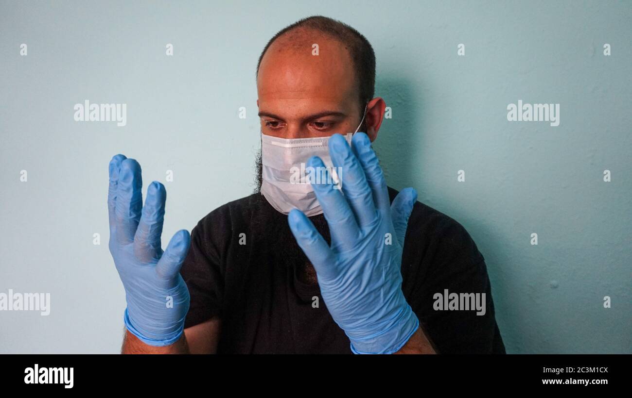 Bearded male wearing a facemask and gloves Stock Photo - Alamy