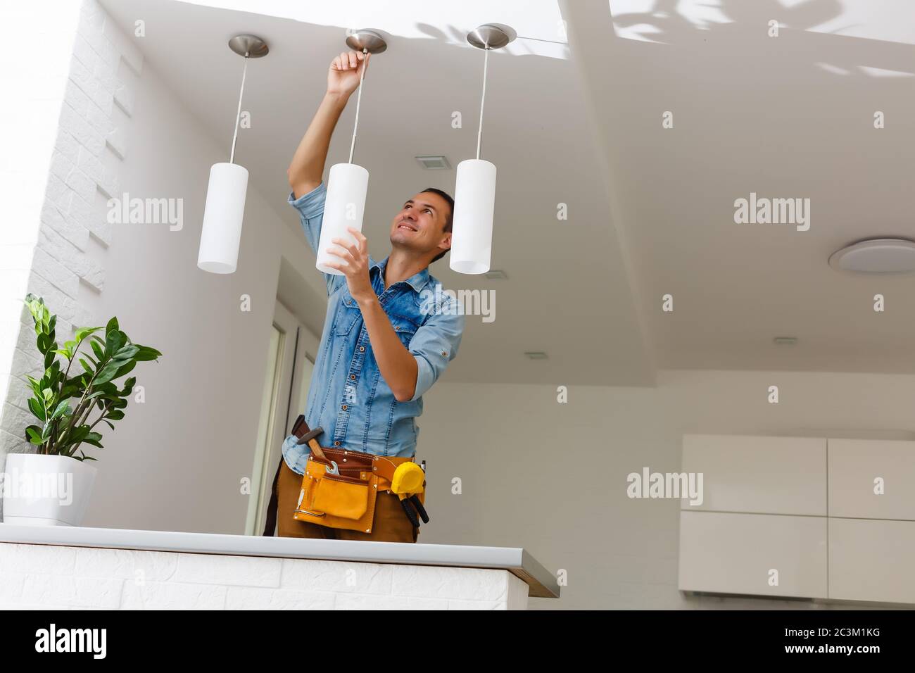 Portrait Of A Male Electrician Fixing Light On Ceiling Stock Photo - Alamy