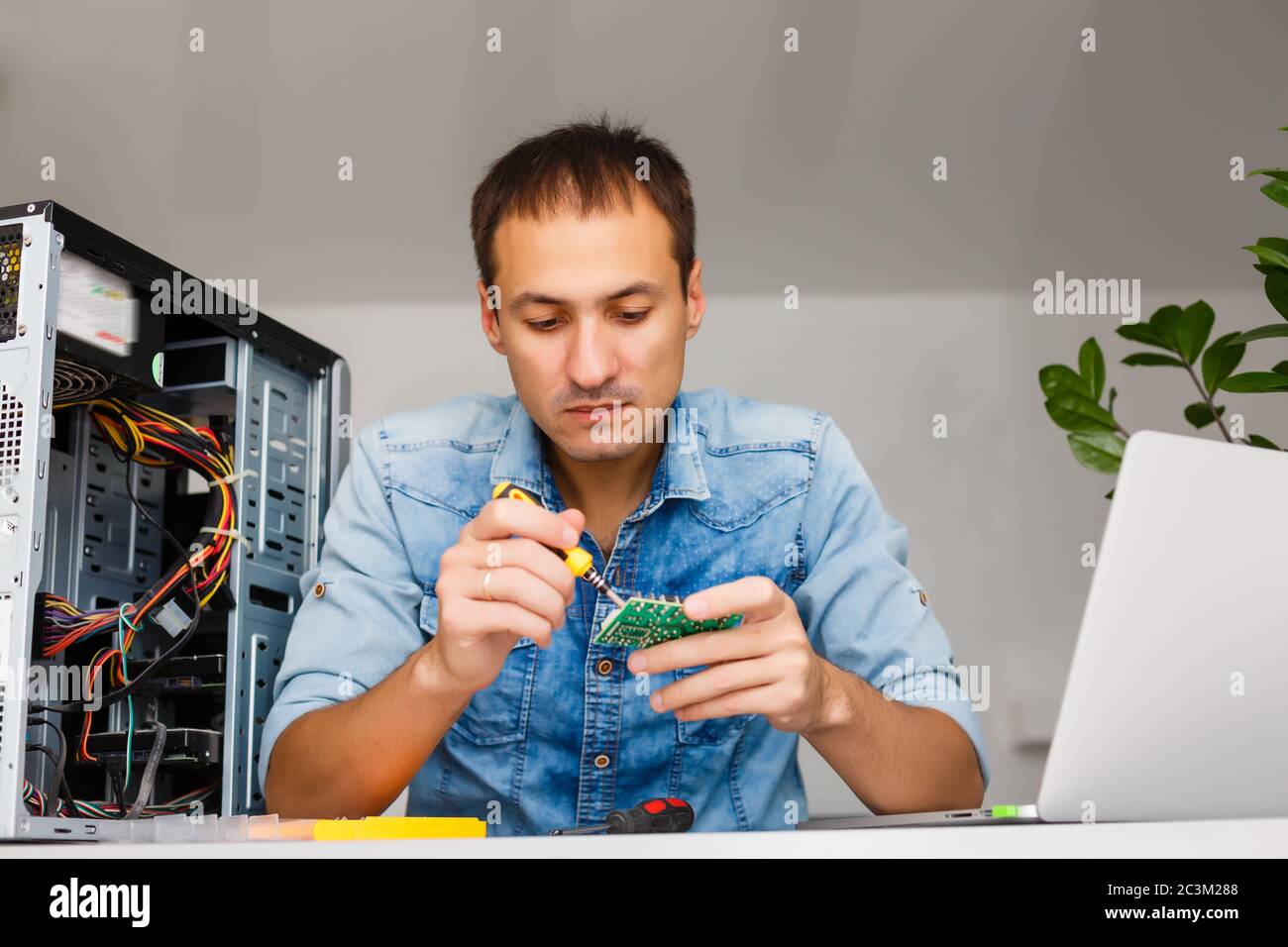 Computer engineer working on broken console in his office Stock Photo ...