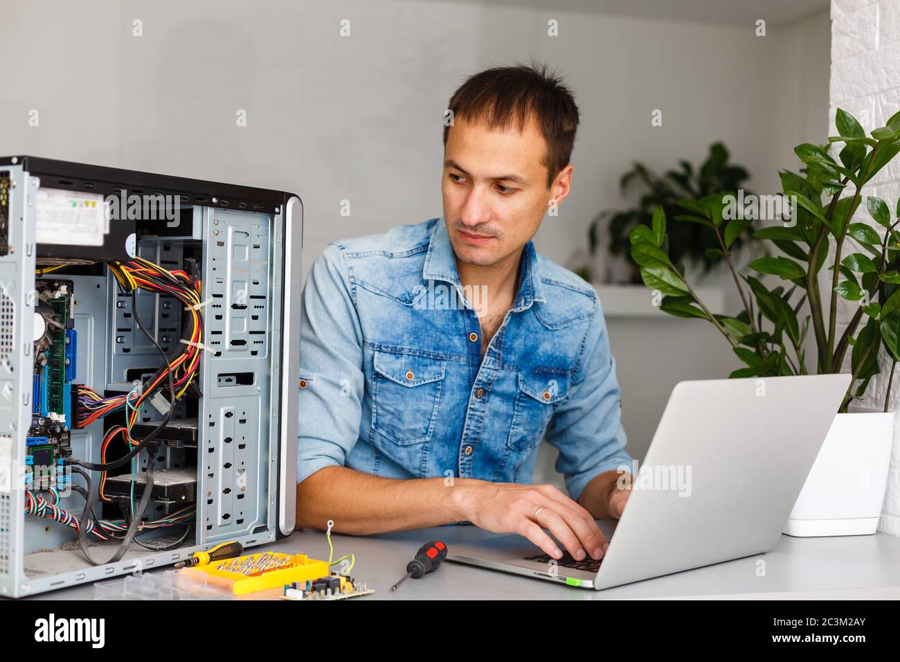 Computer engineer working on broken console in his office Stock Photo ...