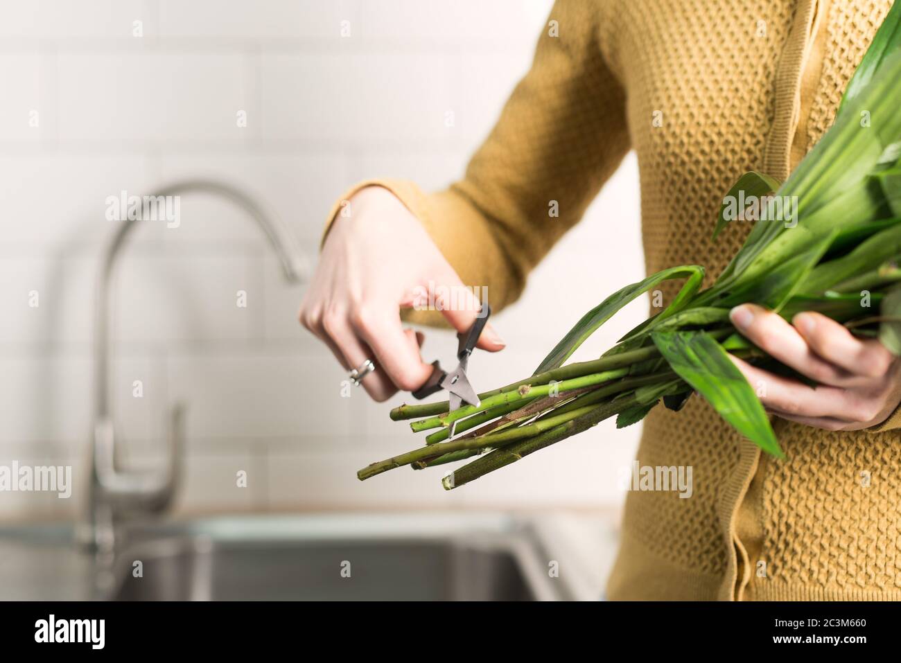 Shot of a female cutting the long ends of the flowers with a scissors ...