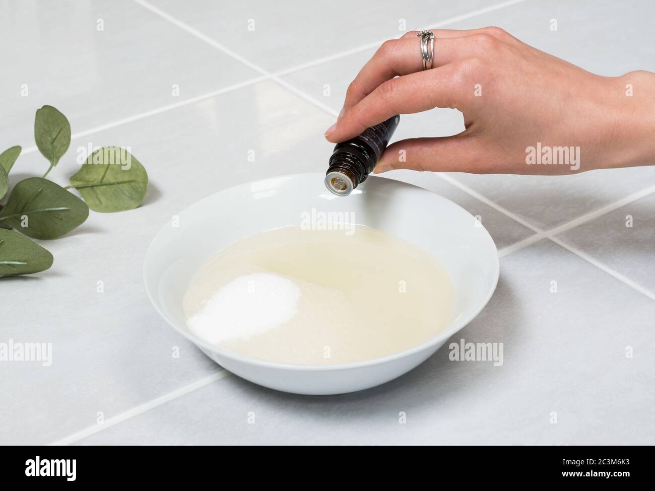 Shot of a female adding something in a plate on the white ceramic ...