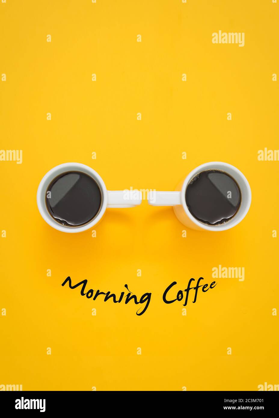 Vertical high angle shot of two cups of coffee on a yellow background ...