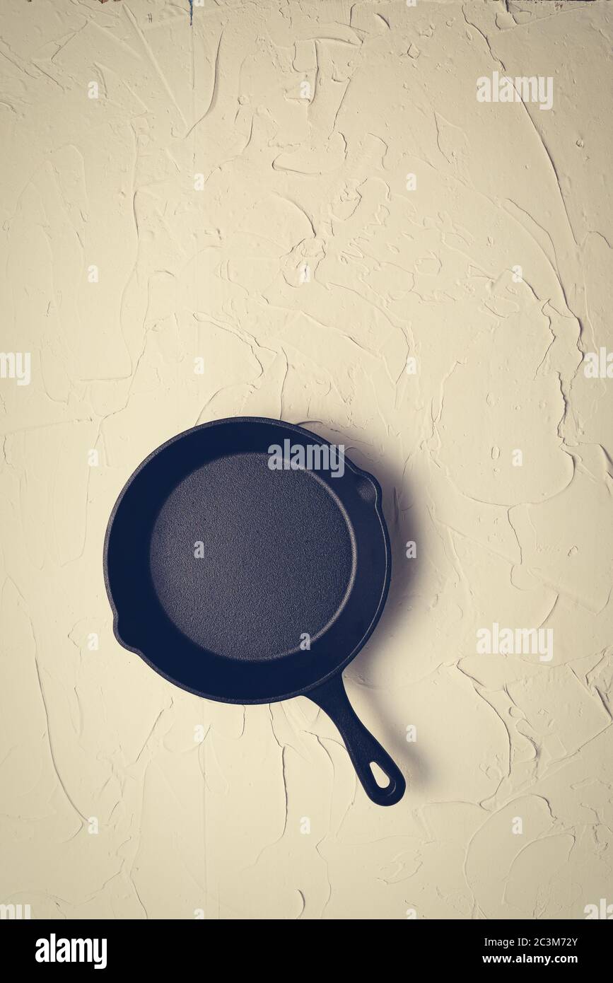 Vertical shot of a black pan on a rough cream surface background Stock ...