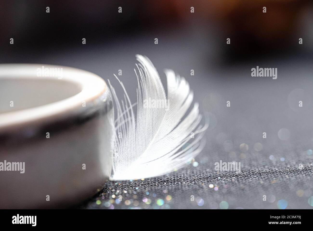 Closeup shot of a small white feather on a textile surface Stock Photo ...