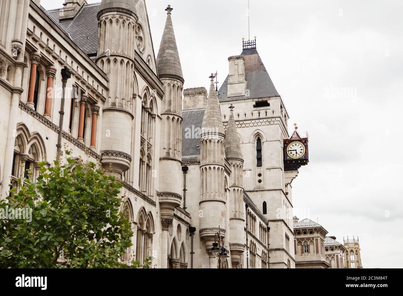 A clock projecting over the pavement on the Royal Courts of Justice ...