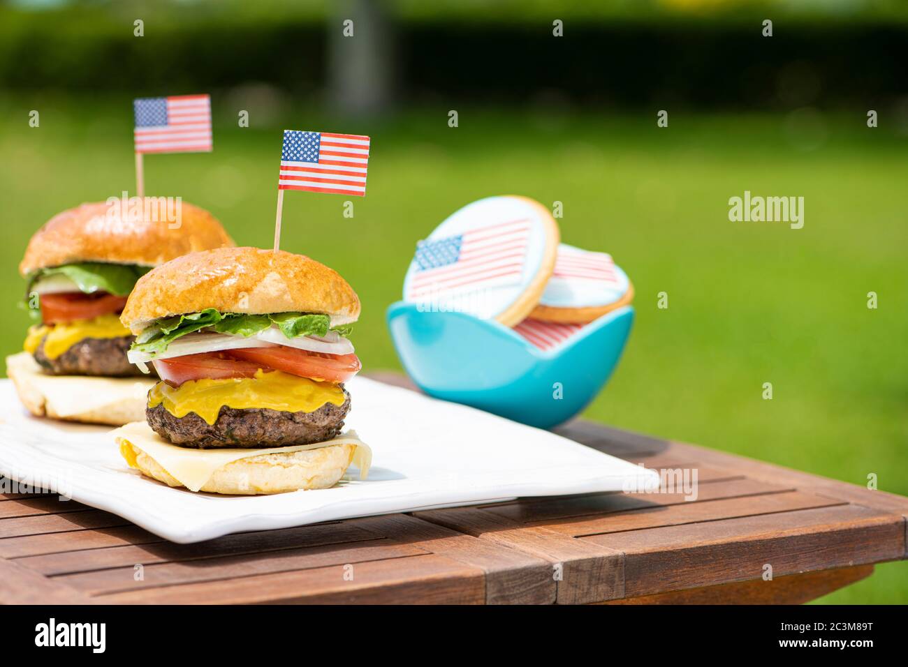 Beef Burgers with American flag on top and a bowl of Cookies with ...