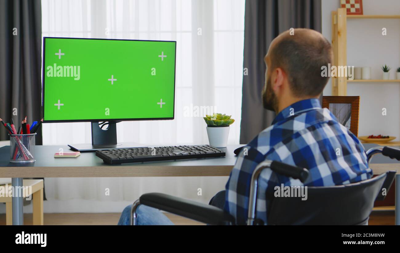 Handicapped man in wheelchair talking with computer Stock Photo - Alamy