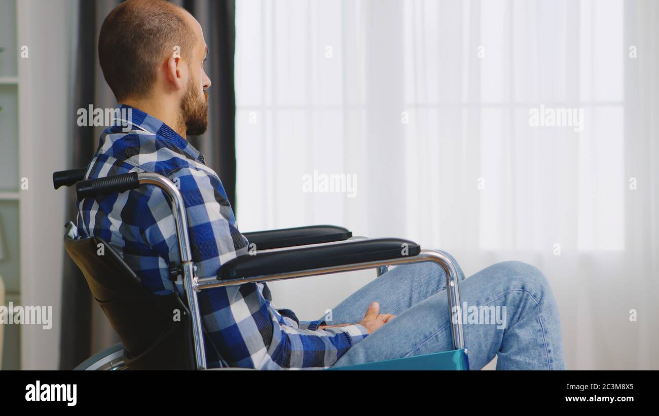 Man with walking disability sitting sad in wheelchair Stock Photo - Alamy