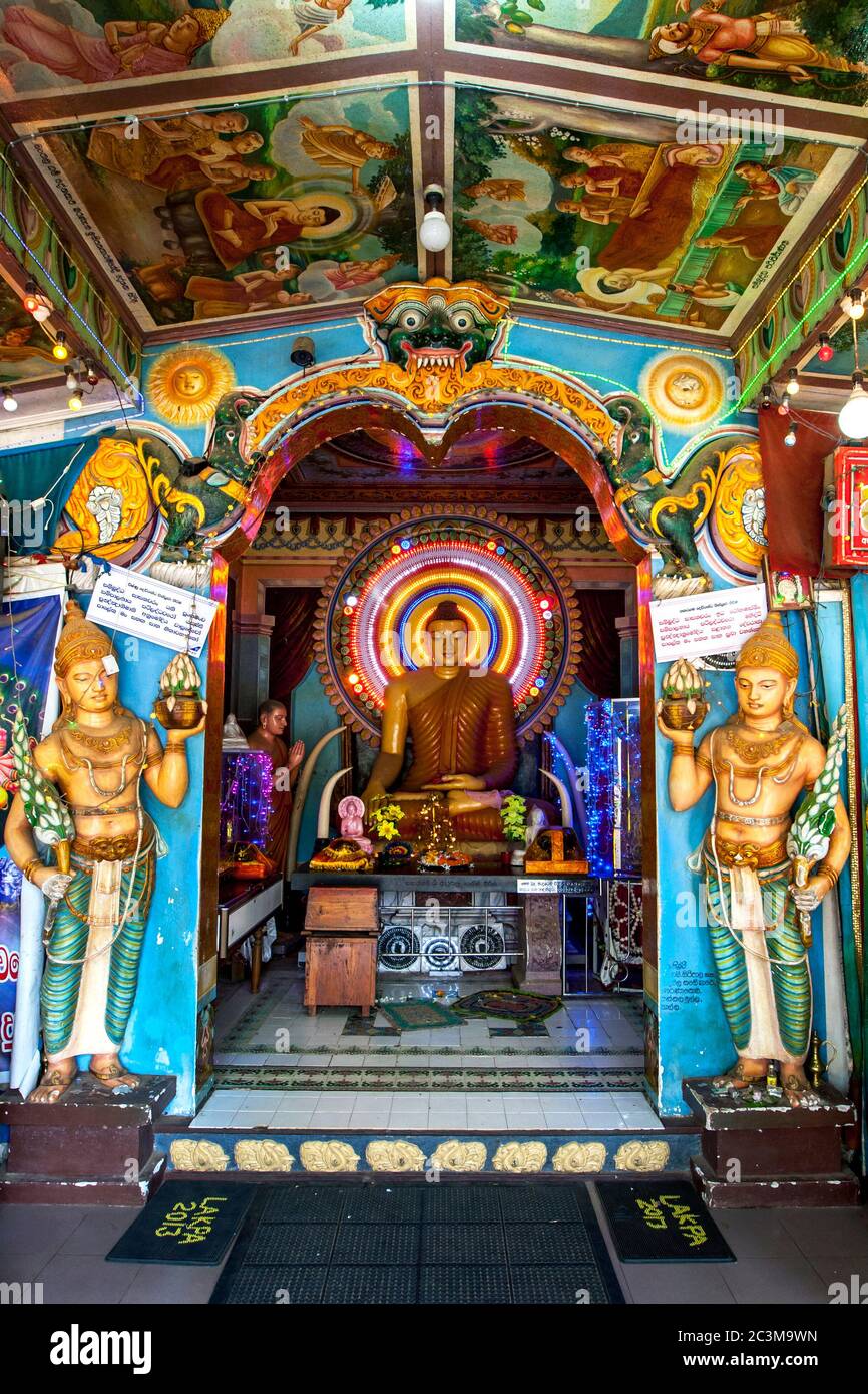 A colourful Buddhist Shrine featuring a seated Buddha statue at the ...