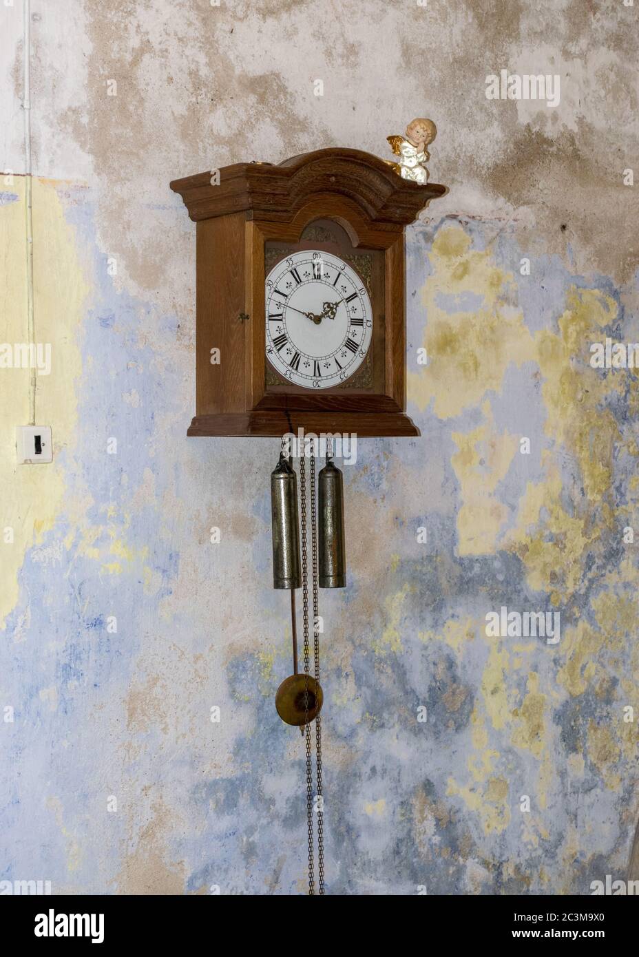 picture with an old wooden clock on the wall in an old castle room ...