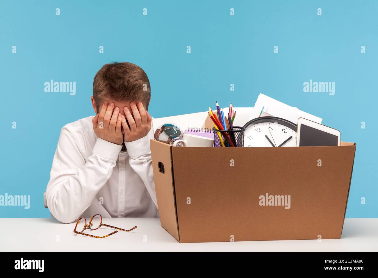 Depressed fired male employee crying hiding face, leaving office ...