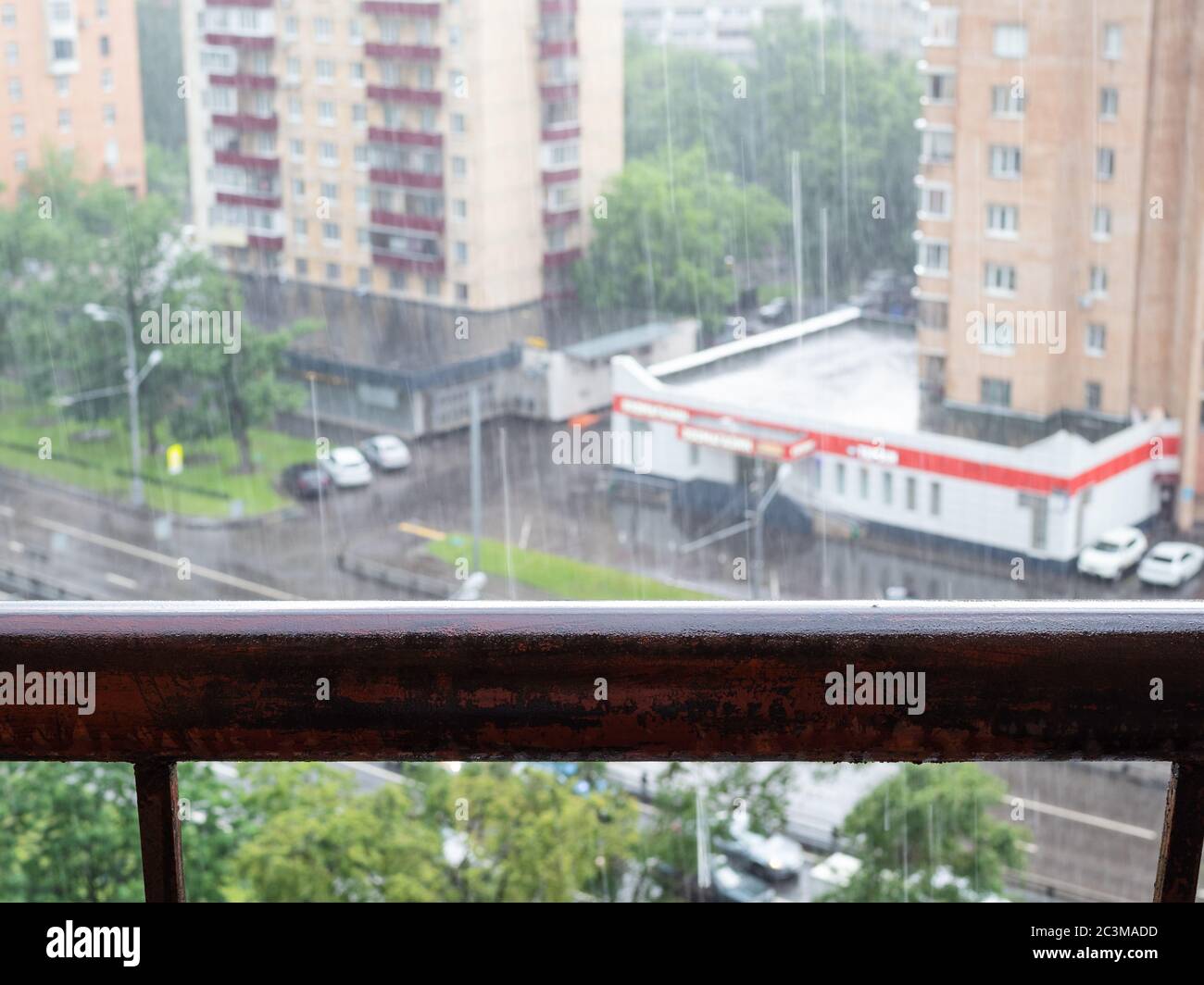 wet balcony railing and above view of blurred street on background in ...