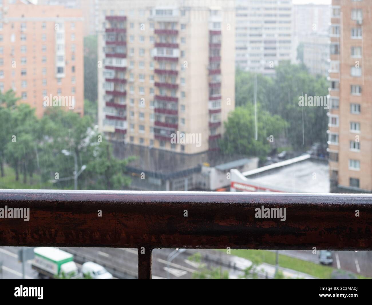 view of wet balcony railing of appartment houses in heavy rain in ...