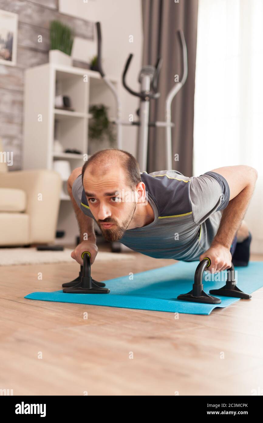 Strong man doing push ups on yoga mat during self isolation Stock Photo ...