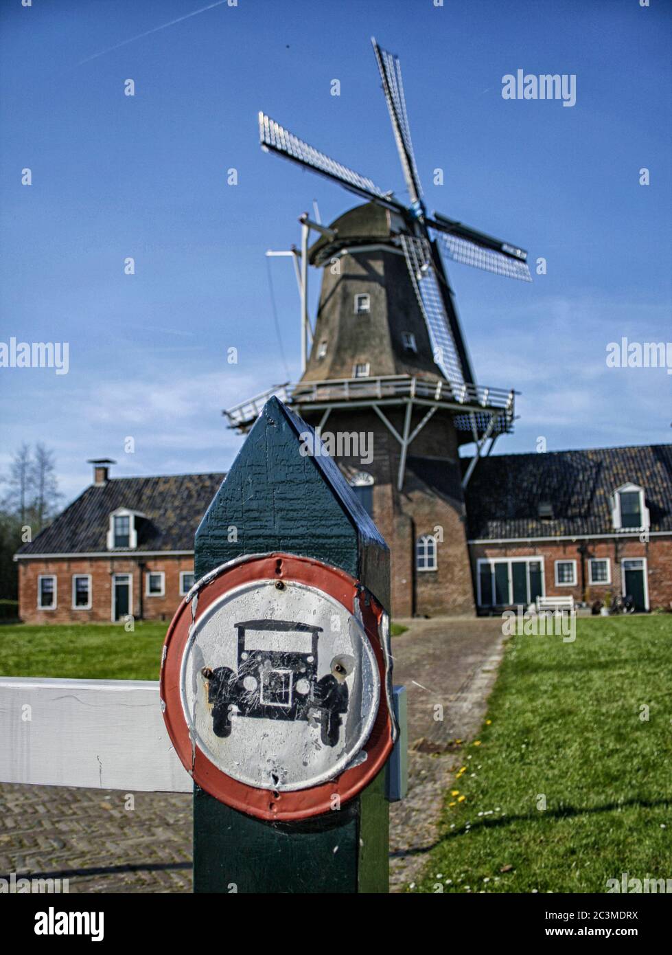 Old windmill built on top of a farm with old fashined sign forbidden ...