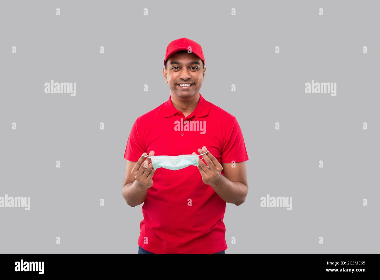 Delivery man Puts on Medical Mask Isolated. Indian Delivery Boy with ...