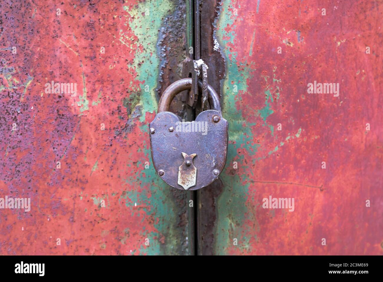 Closed on an old padlock metal door leaf Stock Photo - Alamy