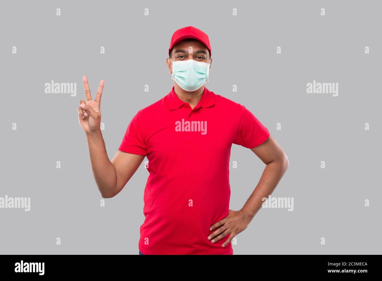 Delivery man Showing Peace Sign Wearing Medical Mask Isolated. Indian ...