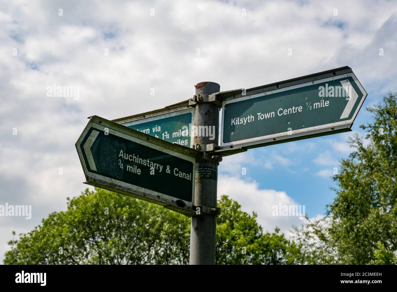 A low-angle shot of a signpost for walkers at a crossroads on a path ...