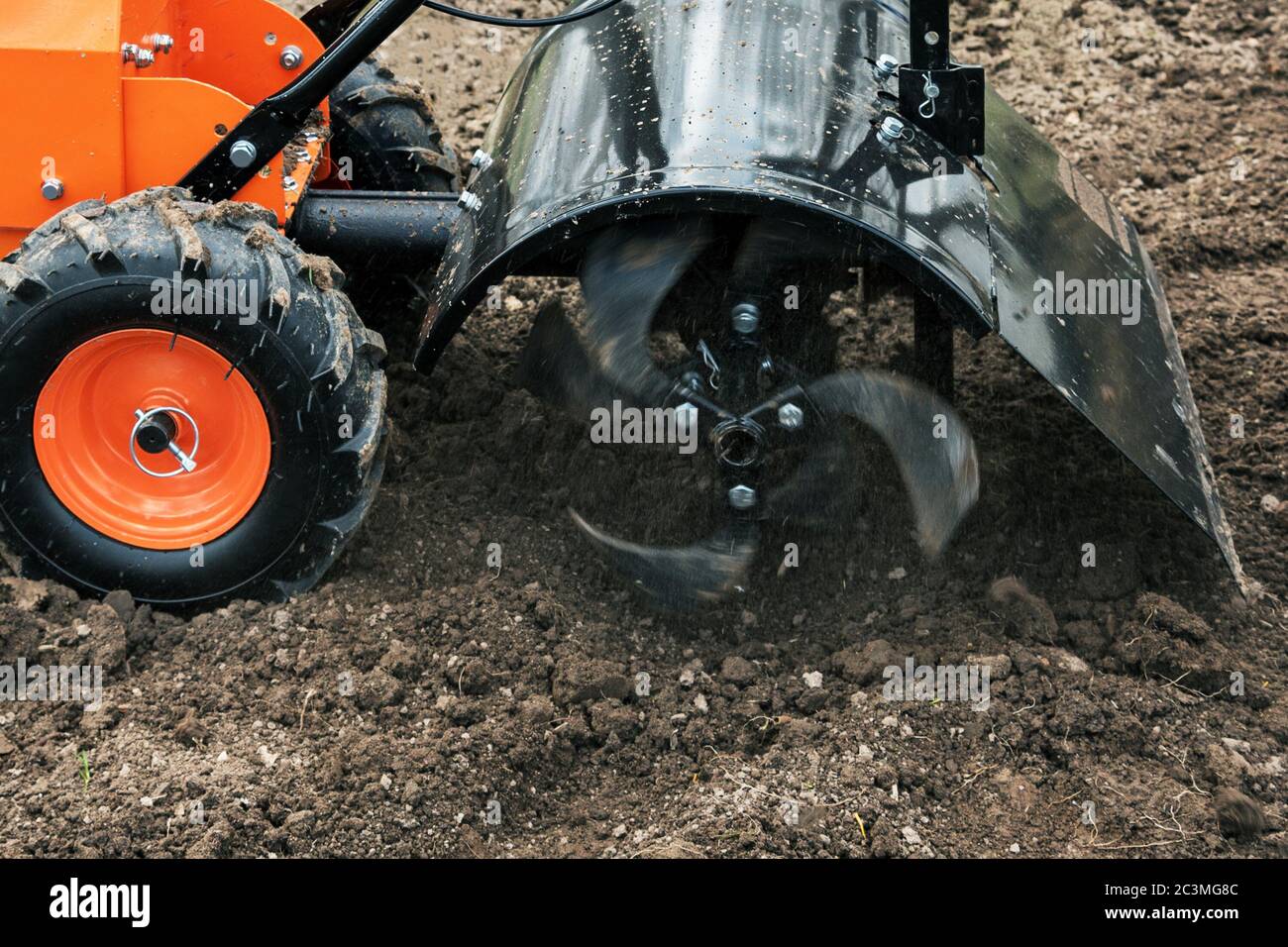 Worker plower earth by motorblock in a spring time Stock Photo - Alamy