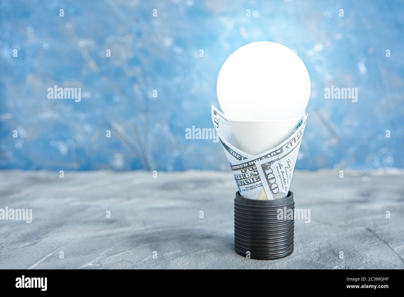 luminous led lamp in an electric socket in a 100 dollar bill ...