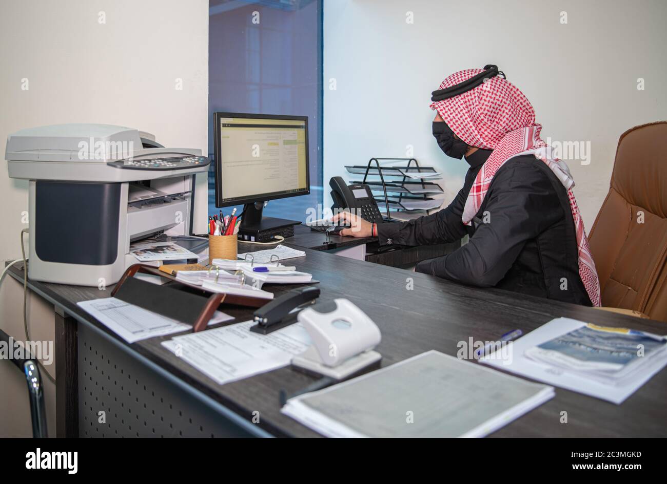 A Saudi man wears a mask and works from the office on the first working ...