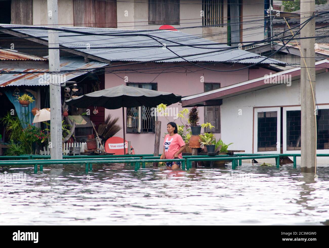 BANGKOK, THAILAND - OCTOBER 17: Woman walking througha flooded ...