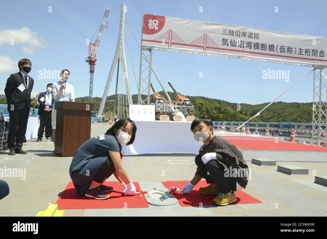 Children attend a ceremony marking the completion of the repair of an ...