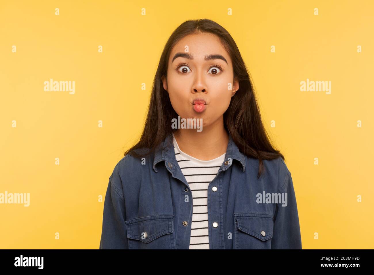Portrait of funny surprised girl in denim shirt making fish face with ...