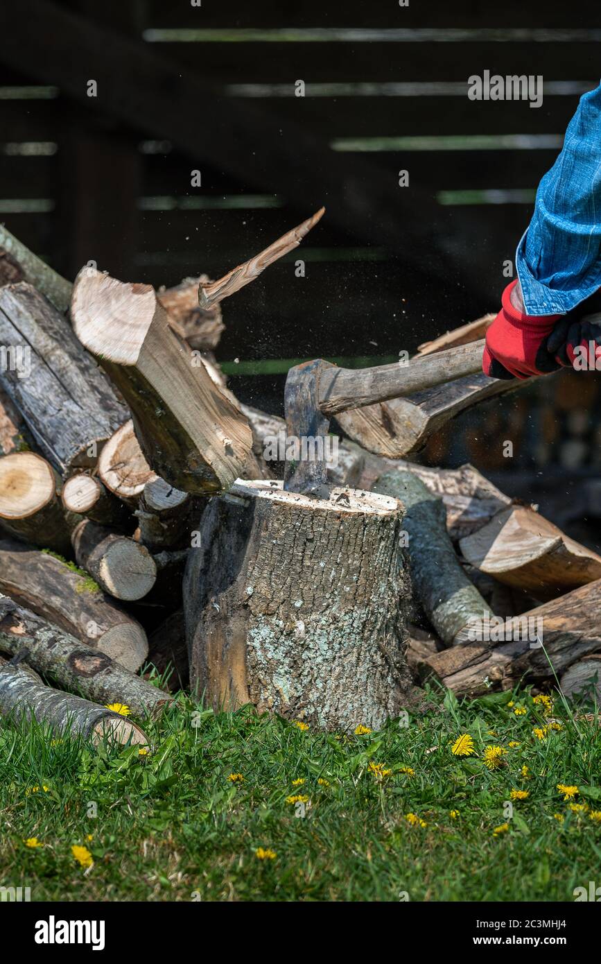 Man works with axe next to the barn Stock Photo - Alamy