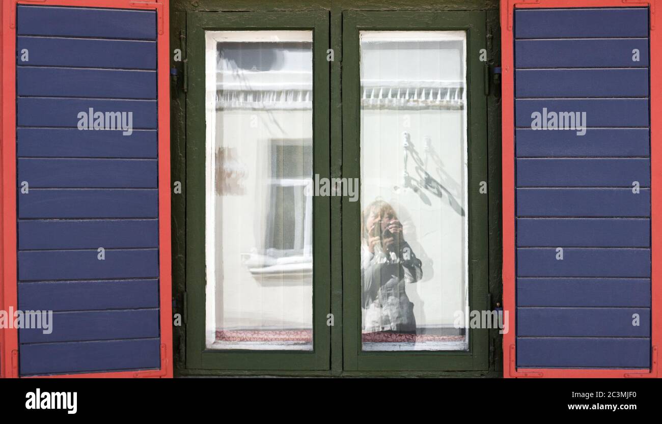 Reflection of photographer in window with shutters Stock Photo - Alamy