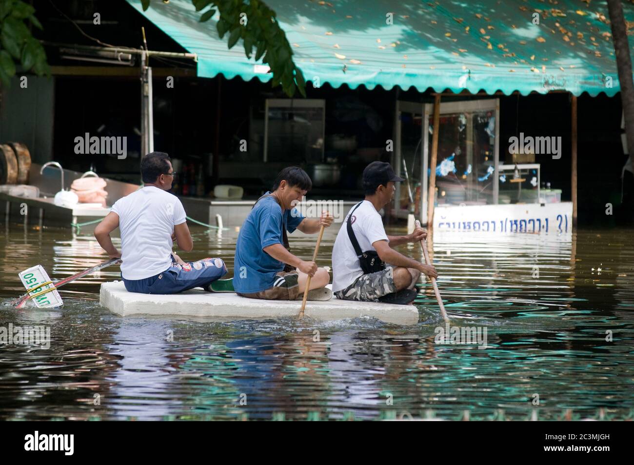 BANGKOK, THAILAND - OCTOBER 29: Three men paddling on a Styrofoam raft ...