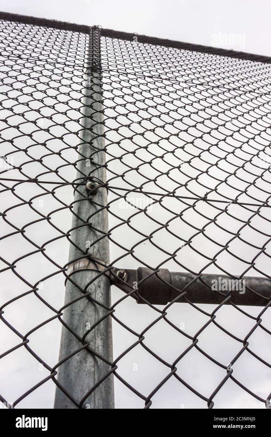 Vertical shot of a metal link fence attached to a pole Stock Photo - Alamy