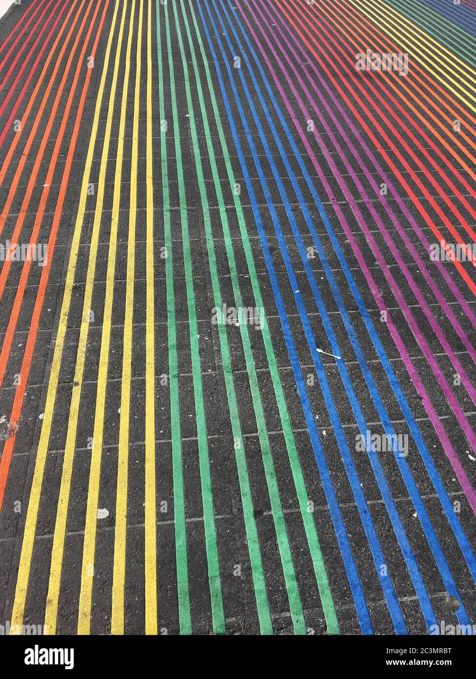 Vertical low angle shot of a beautiful wall painted in rainbow lines ...