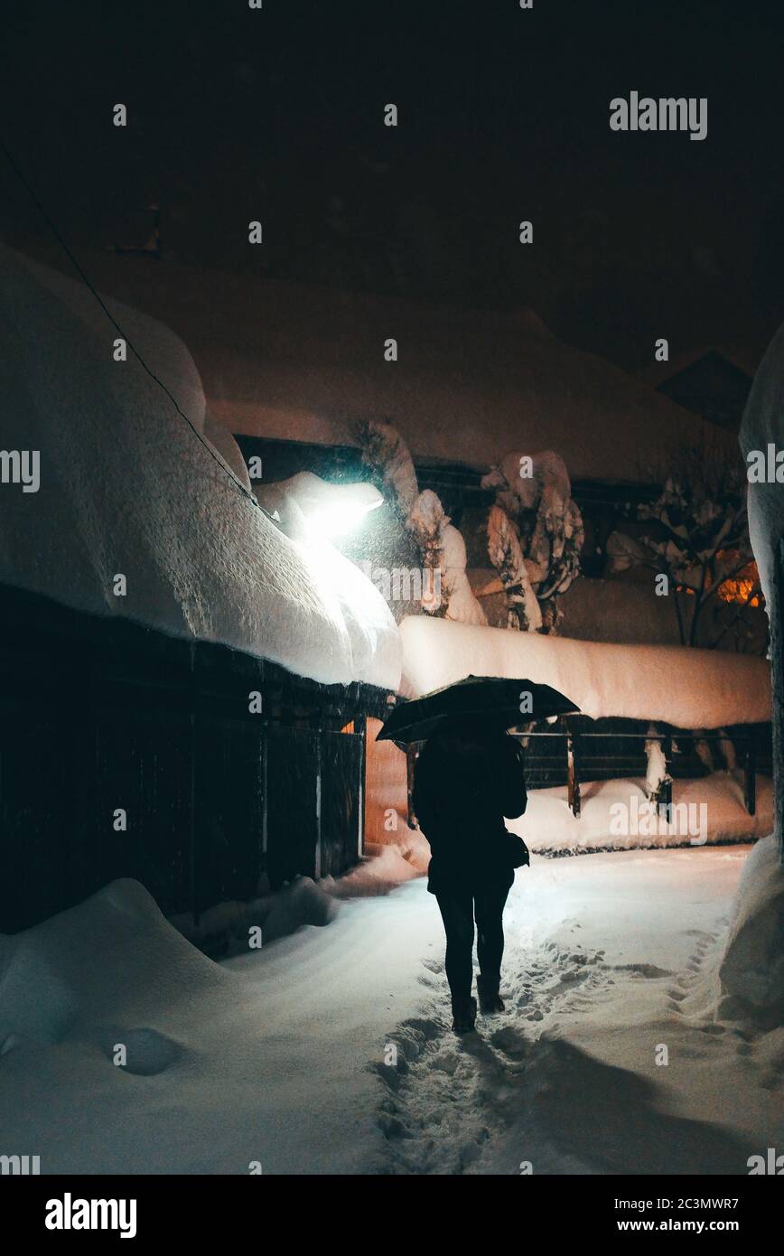 Man walkng on a snowy alley with an umbrella, at night Stock Photo - Alamy