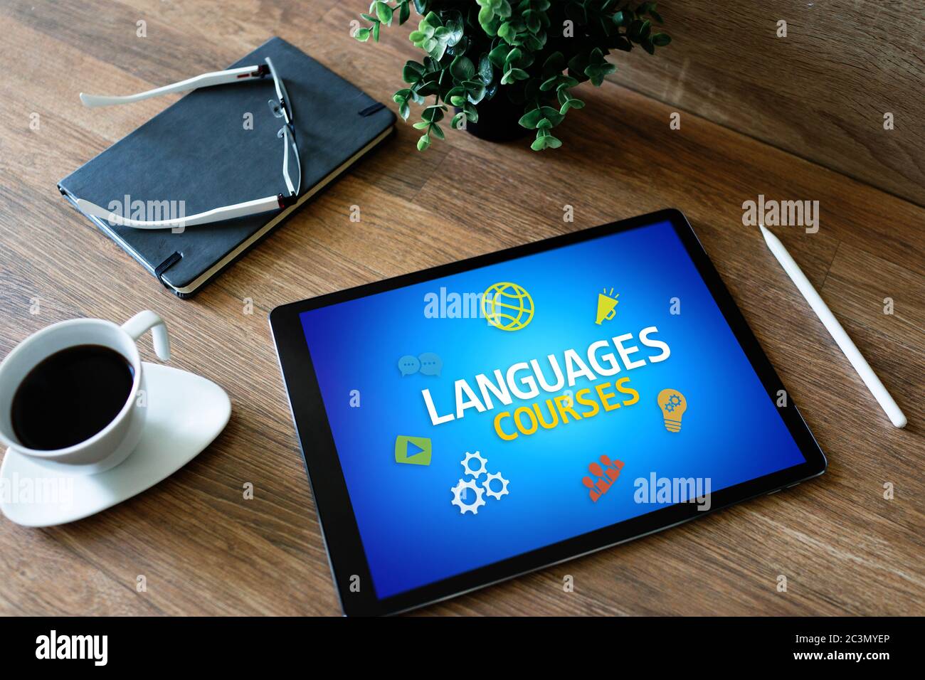 Tablet with languages courses text and icons on screen. English ...