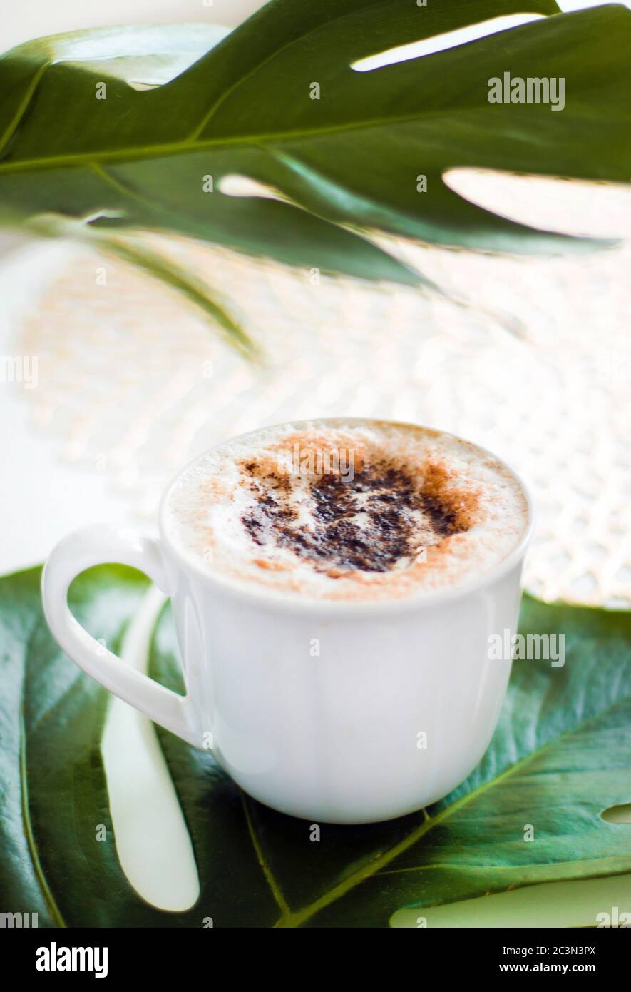 High angle closeup shot of a cup of coffee on a green leaf Stock Photo ...