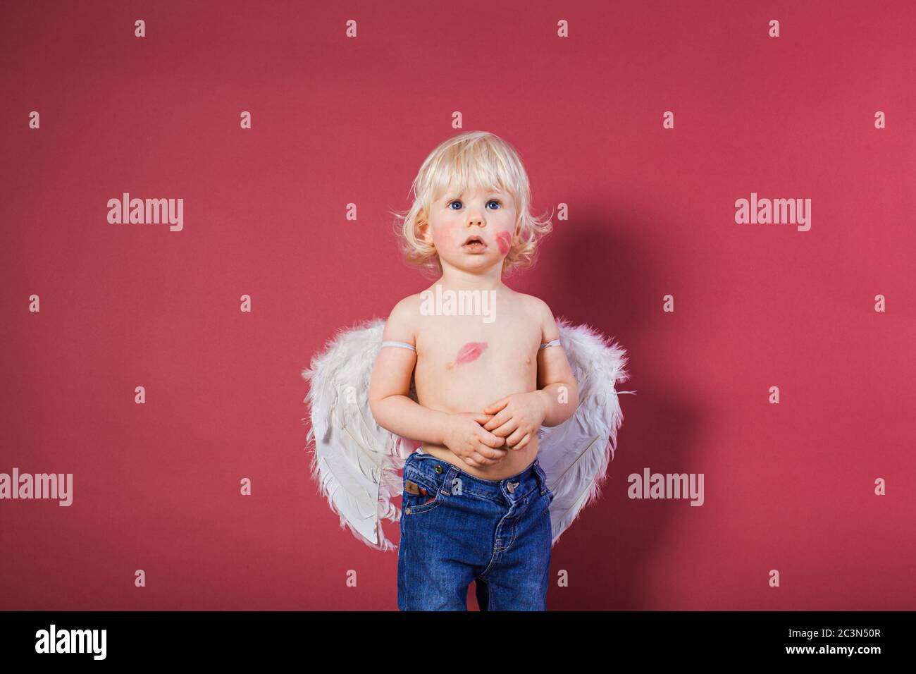 Cute boy with angel wings strares on something Stock Photo - Alamy