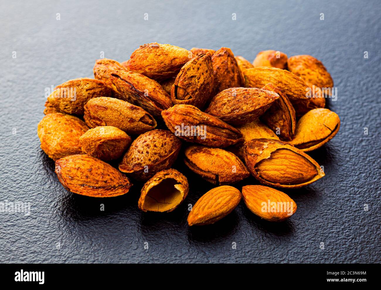 Pile of raw unpeeled almond on grey surface Stock Photo - Alamy