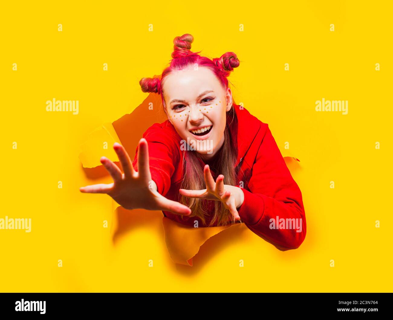Emotional young woman breaking through hole in a wall Stock Photo - Alamy