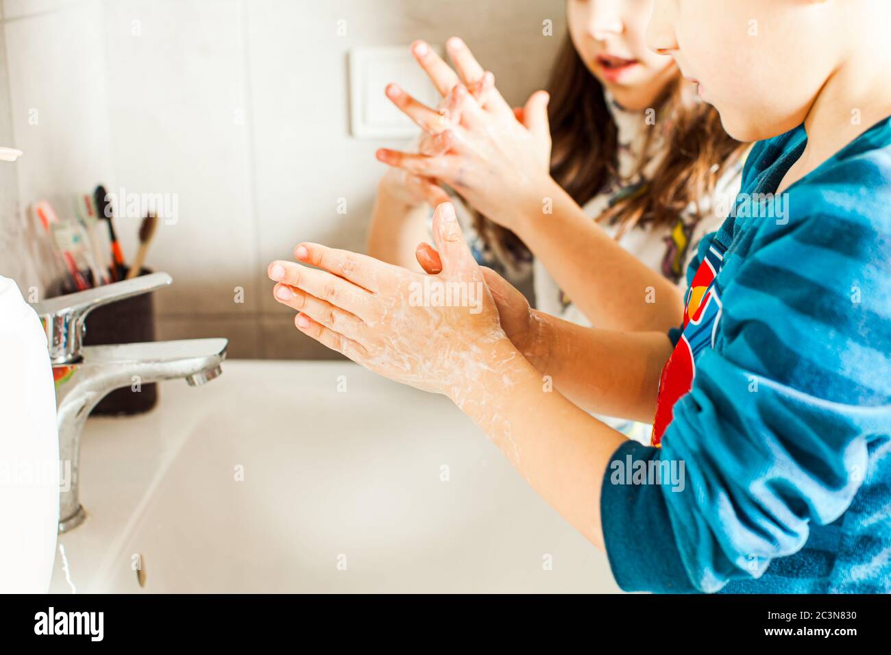 Boy and girl washing their hands with soap Stock Photo - Alamy