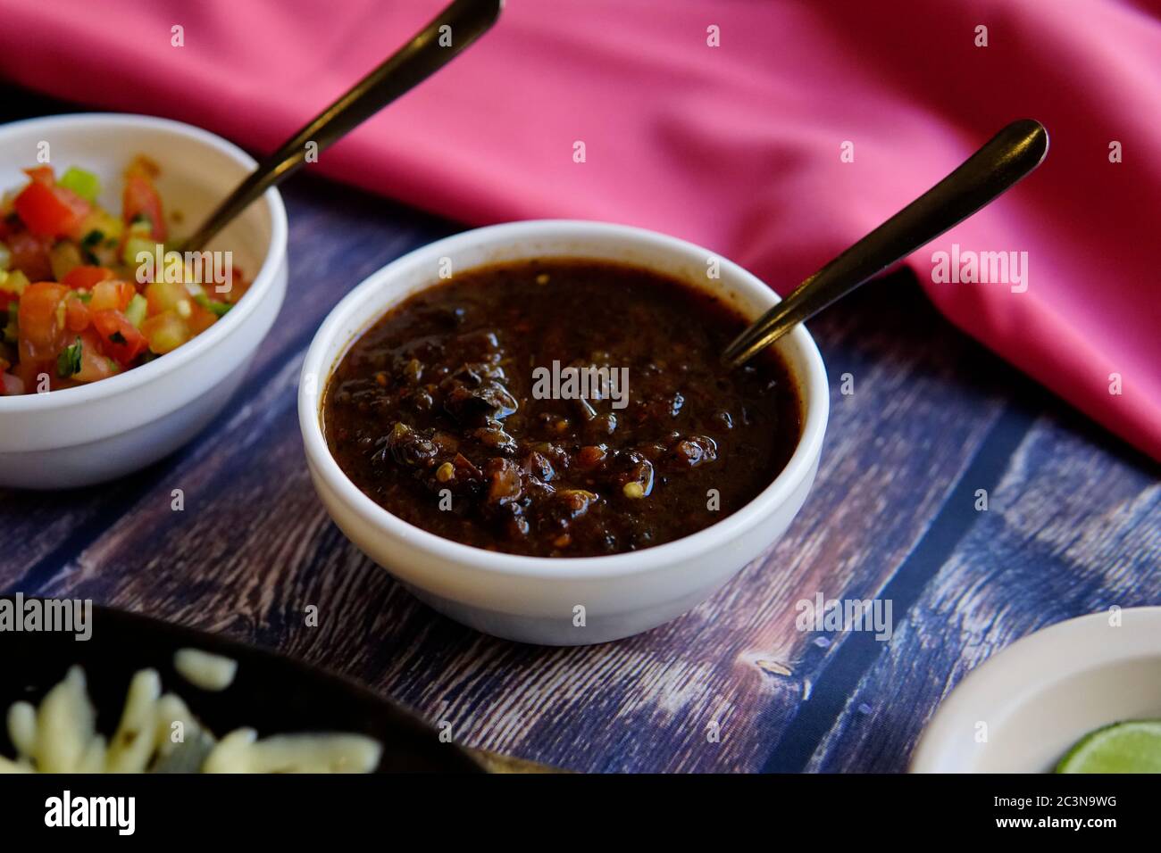 High angle closeup shot of a sauce in a white bowl on a wooden table ...